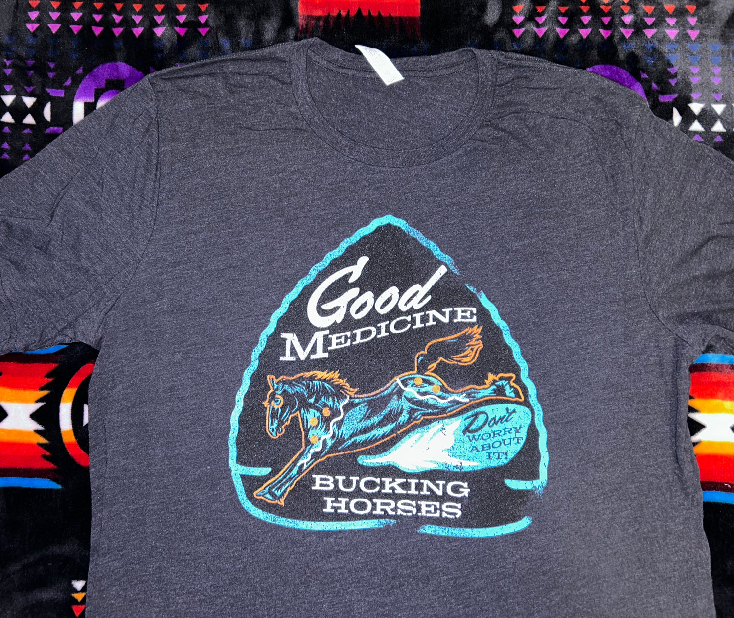 Good Medicine Bucking Horses “Distressed” Black Arrowhead Tee – Dougie Hall